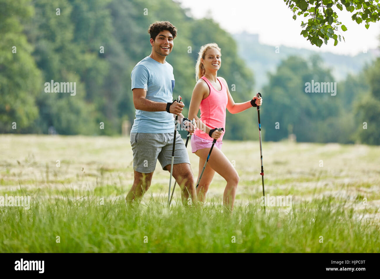 Young couple hiking in the nature nordic walking Stock Photo - Alamy