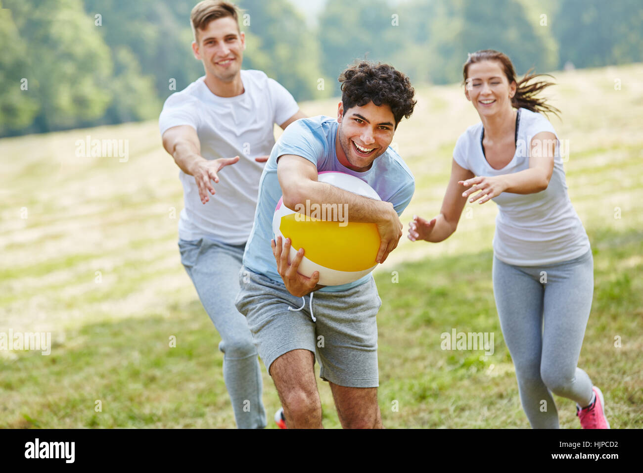 Friends playing in the park and having fun with a ball Stock Photo - Alamy