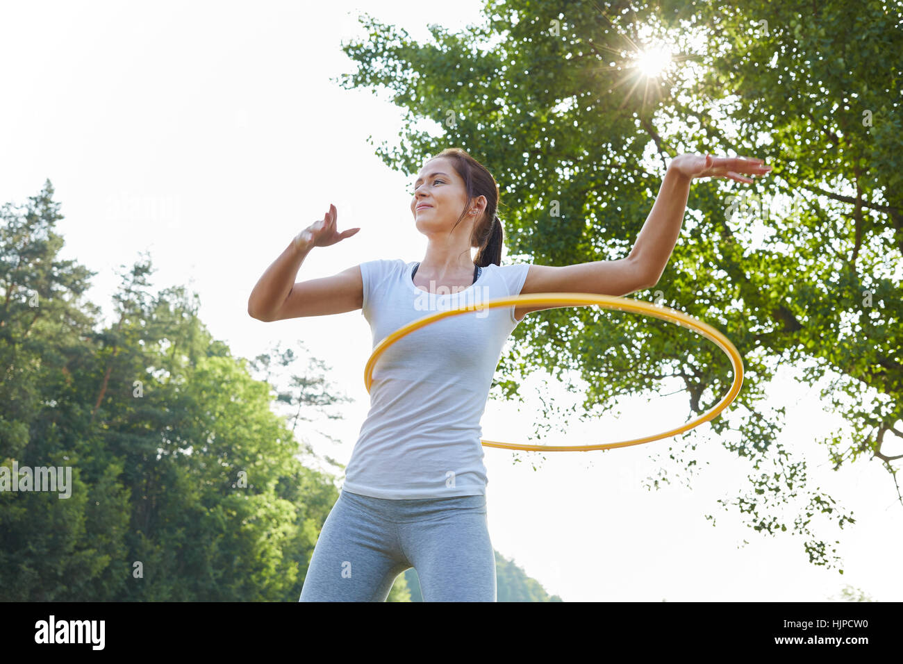 Young woman training movement and active sport with hoop Stock Photo ...