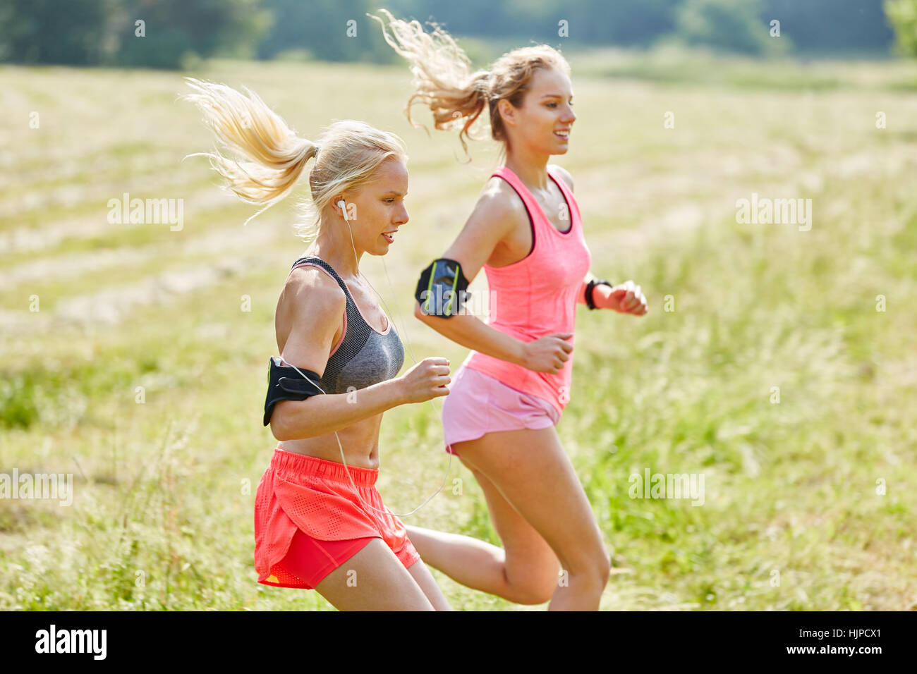 Two young women running together as friends in the nature Stock Photo ...