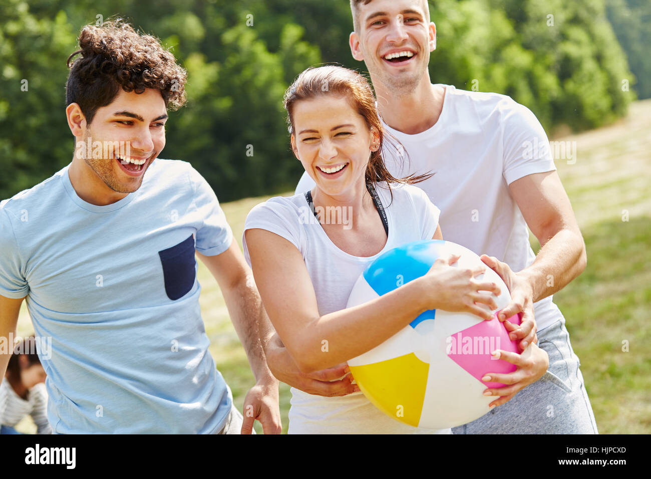 Friends laughing and playing with ball in the park Stock Photo - Alamy