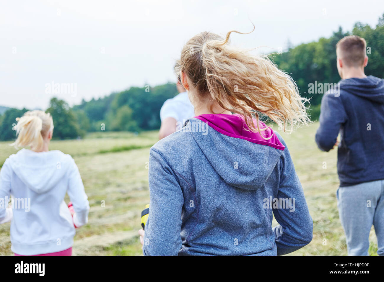 Group running during fitness training at the park Stock Photo - Alamy