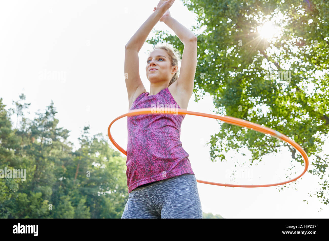 Woman trains her agility with hoop and rotates it around her body Stock ...