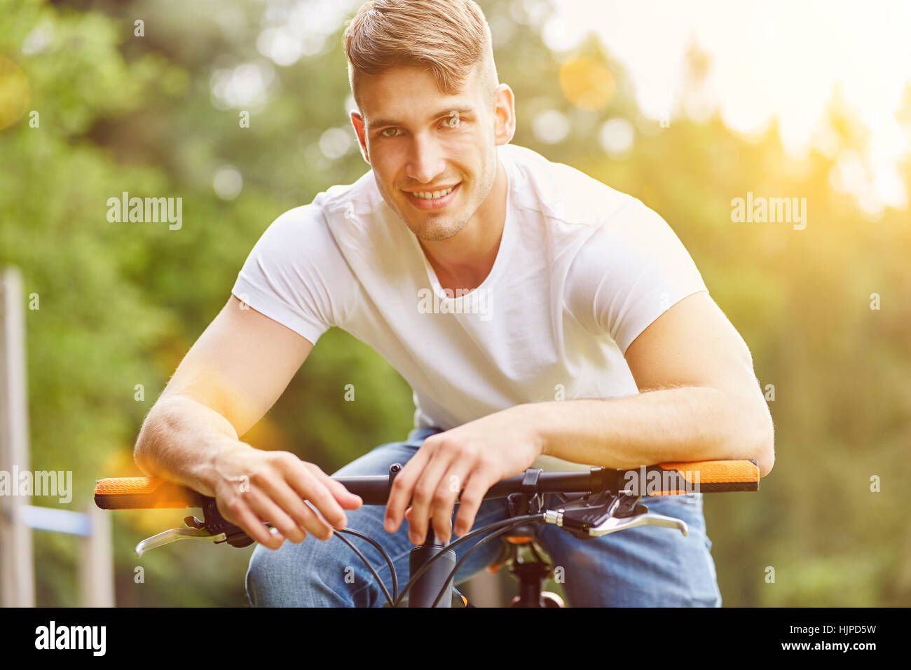 Young man with bicycle in summer in the nature Stock Photo - Alamy