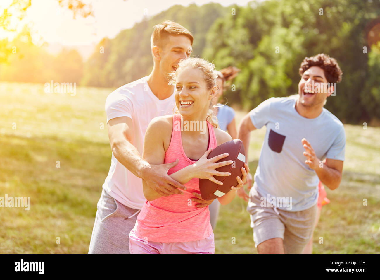 Group of teenagers playing rugby in the park in summer Stock Photo - Alamy