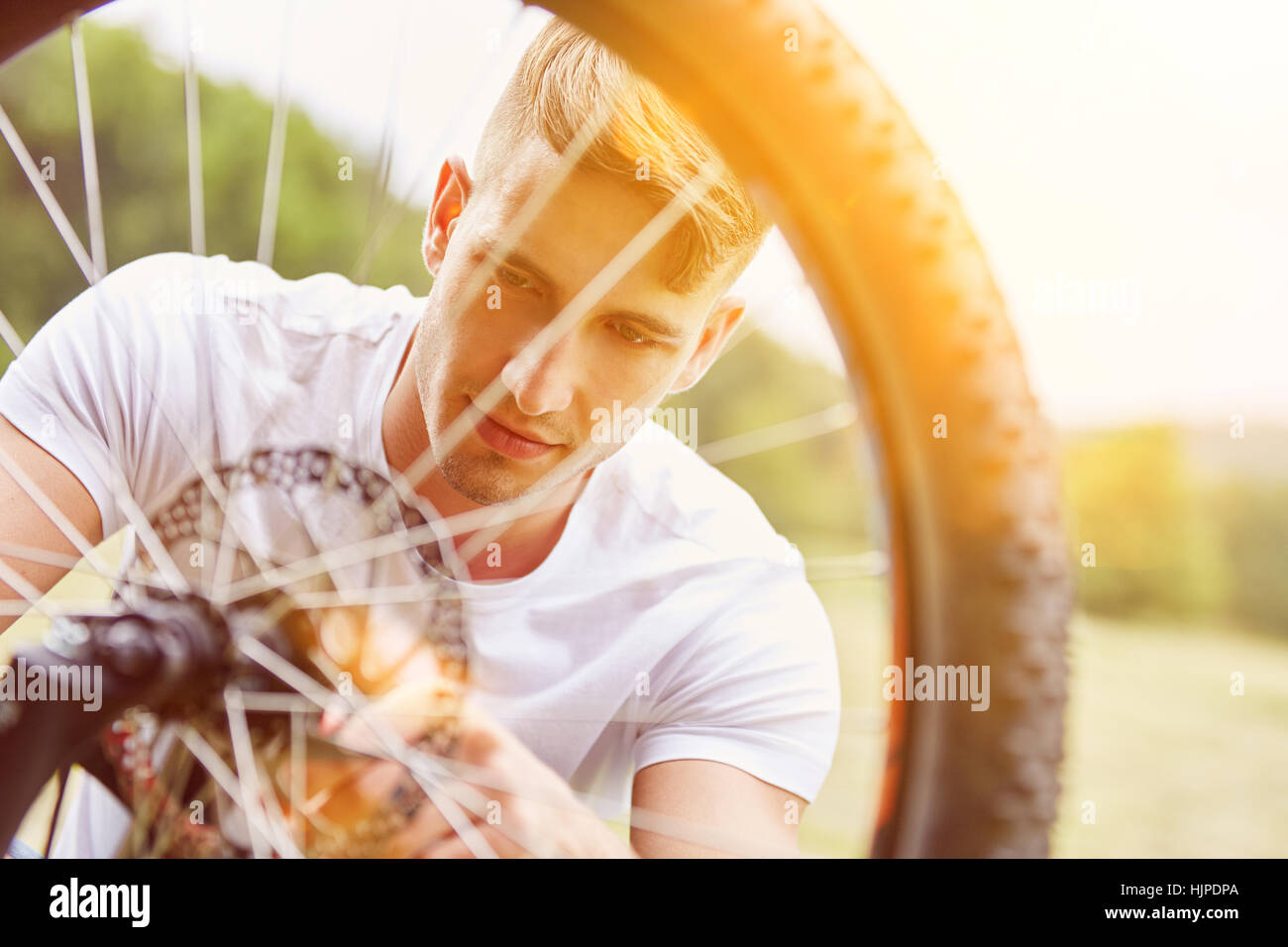 Man repairs bicycle after breakdown in summer Stock Photo - Alamy