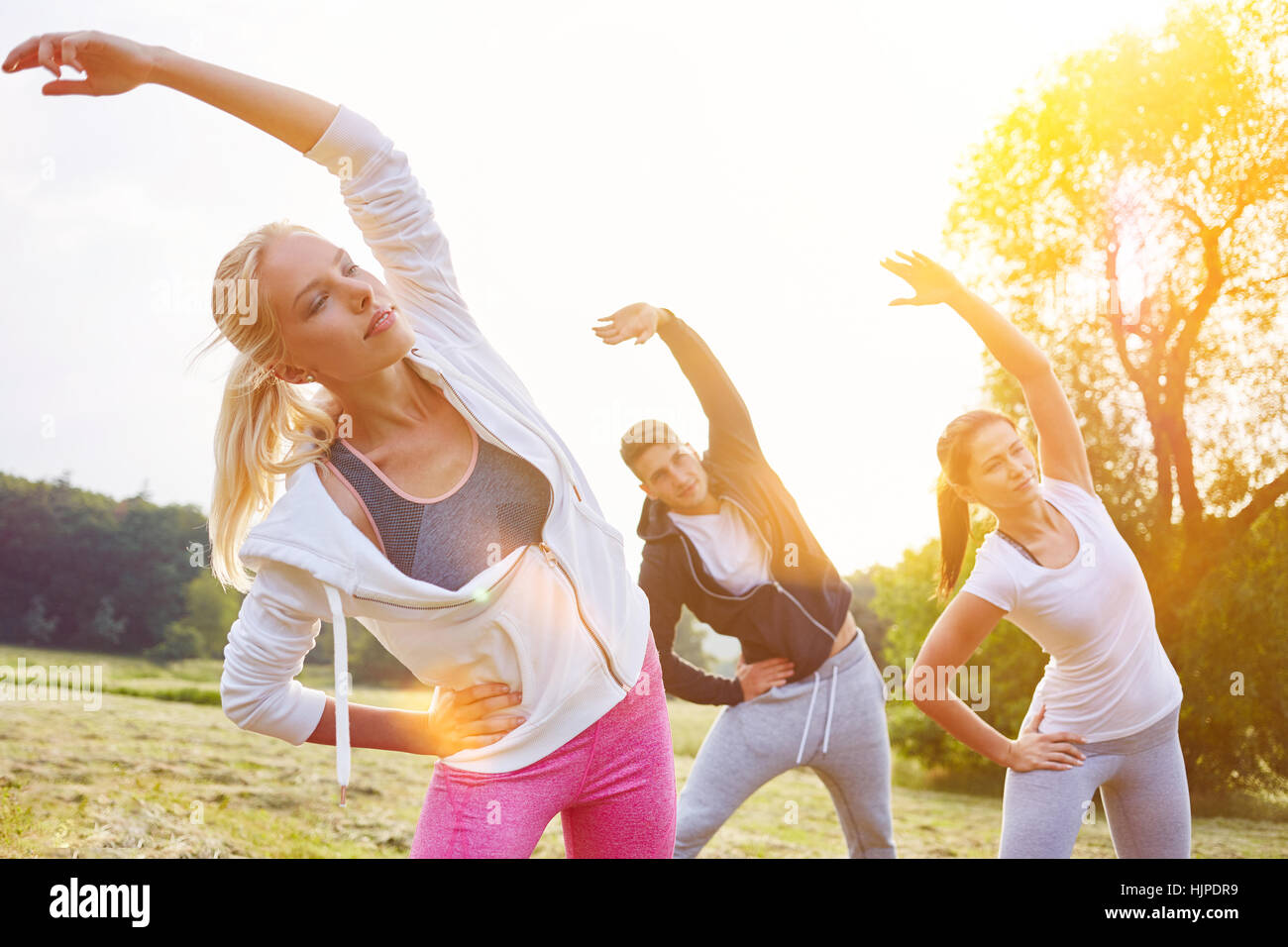 Fitness group warming up before training in summer Stock Photo - Alamy