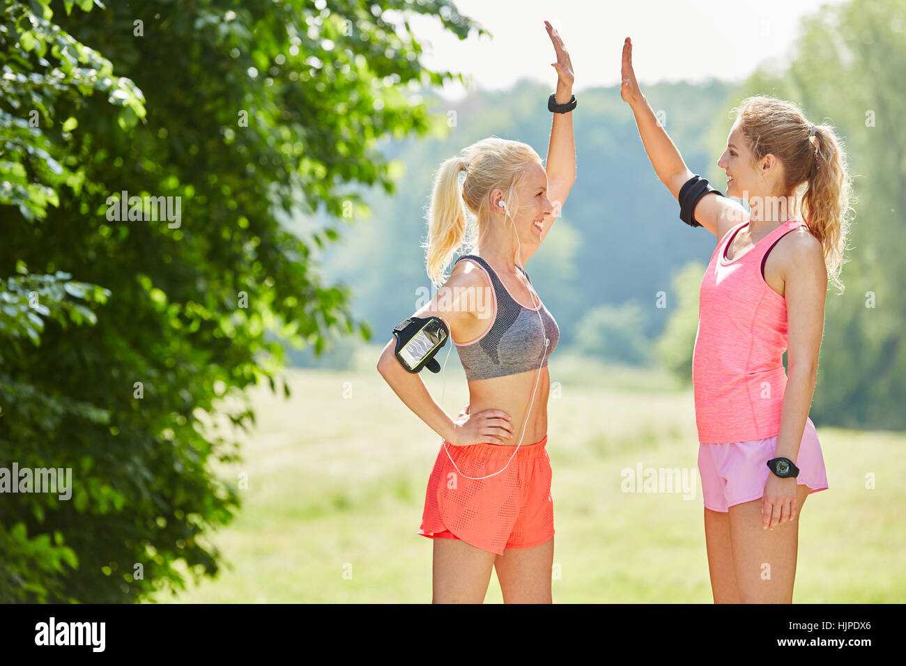 Two woman giving High Five in the air to each other as sign of success ...