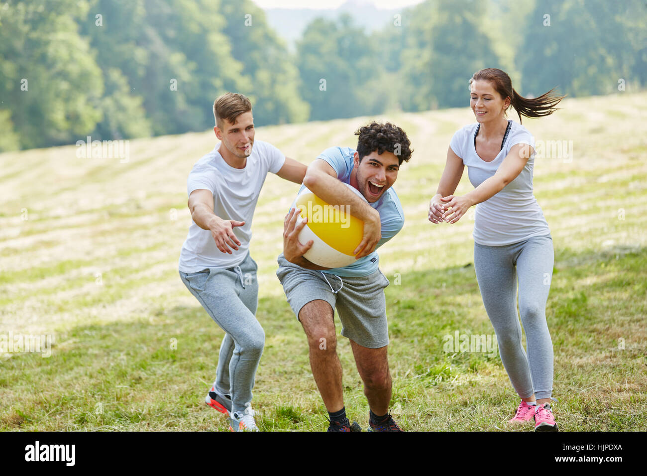Young people as friends playing with ball in the park Stock Photo - Alamy