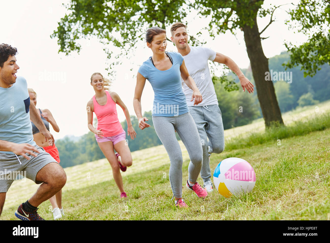 Friends playing with ball in movement having fun and being active Stock ...