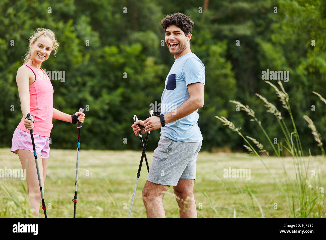 Young couple nordic walking together in summer Stock Photo - Alamy