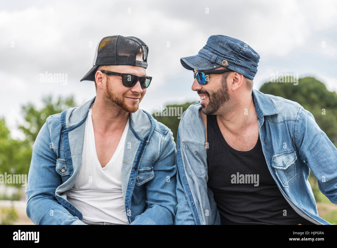 Group of men sitting on a wall and talking hi-res stock photography and ...