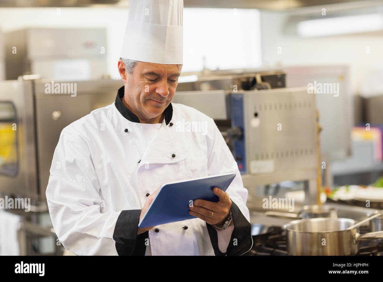 Chef using his digital tablet in the kitchen Stock Photo - Alamy