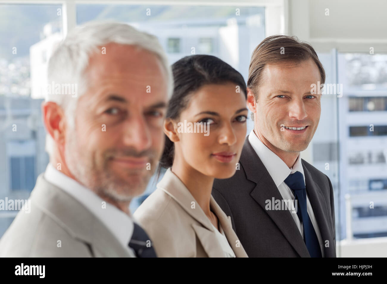 Serious business people looking in the same way in their office Stock ...