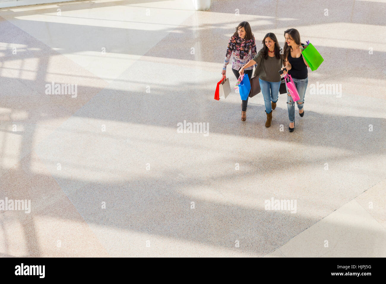 Happy girls walking shopping at the mall Stock Photo - Alamy