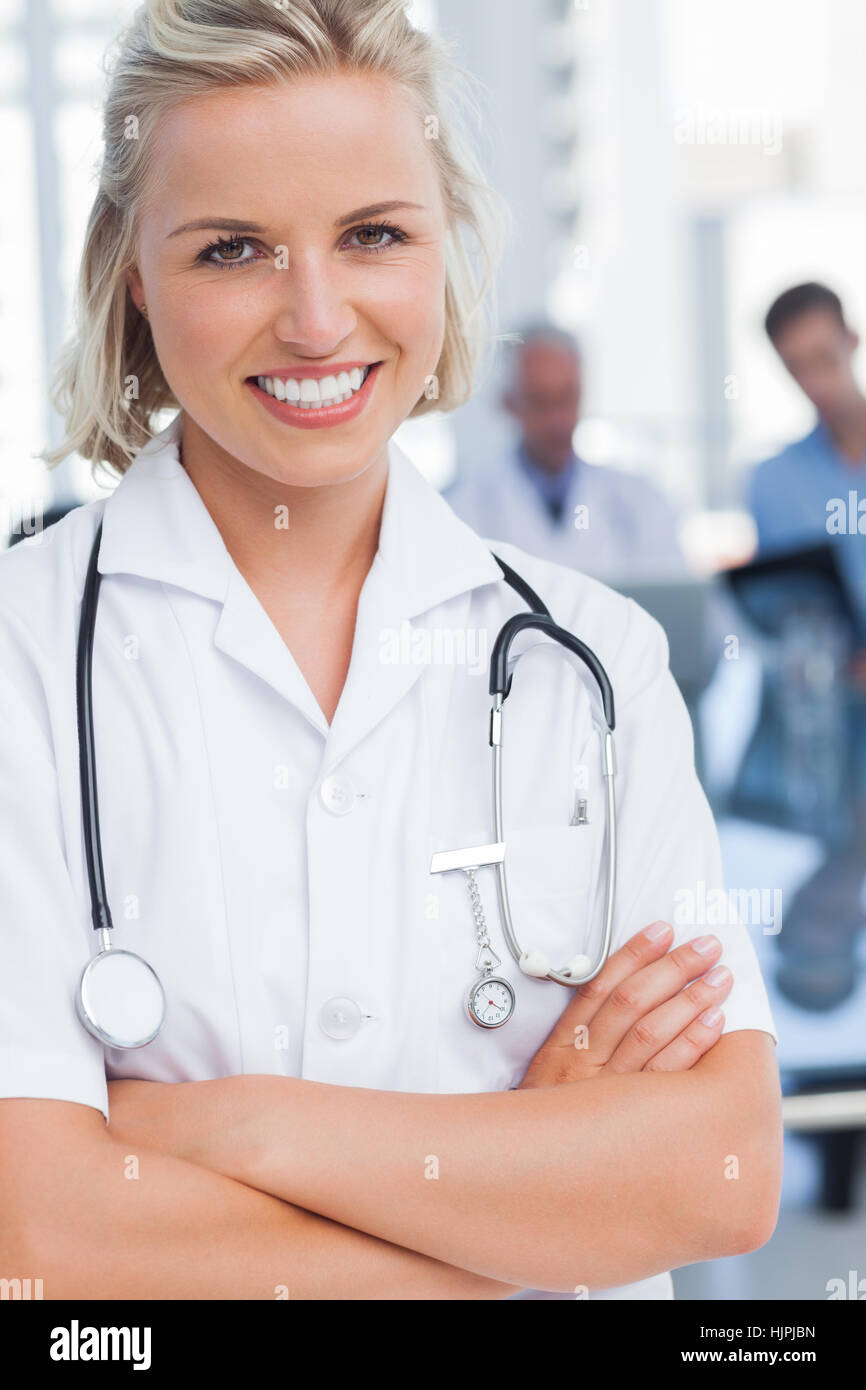 Young nurse with arms crossed in front of her medical team Stock Photo ...