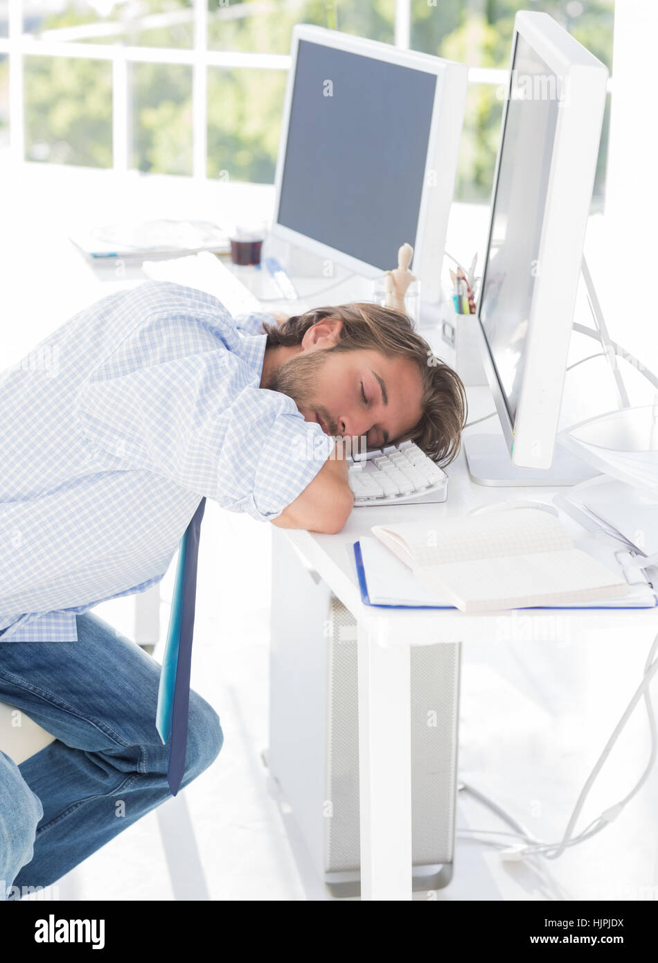 Designer asleep at his desk on the keyboard in office Stock Photo - Alamy