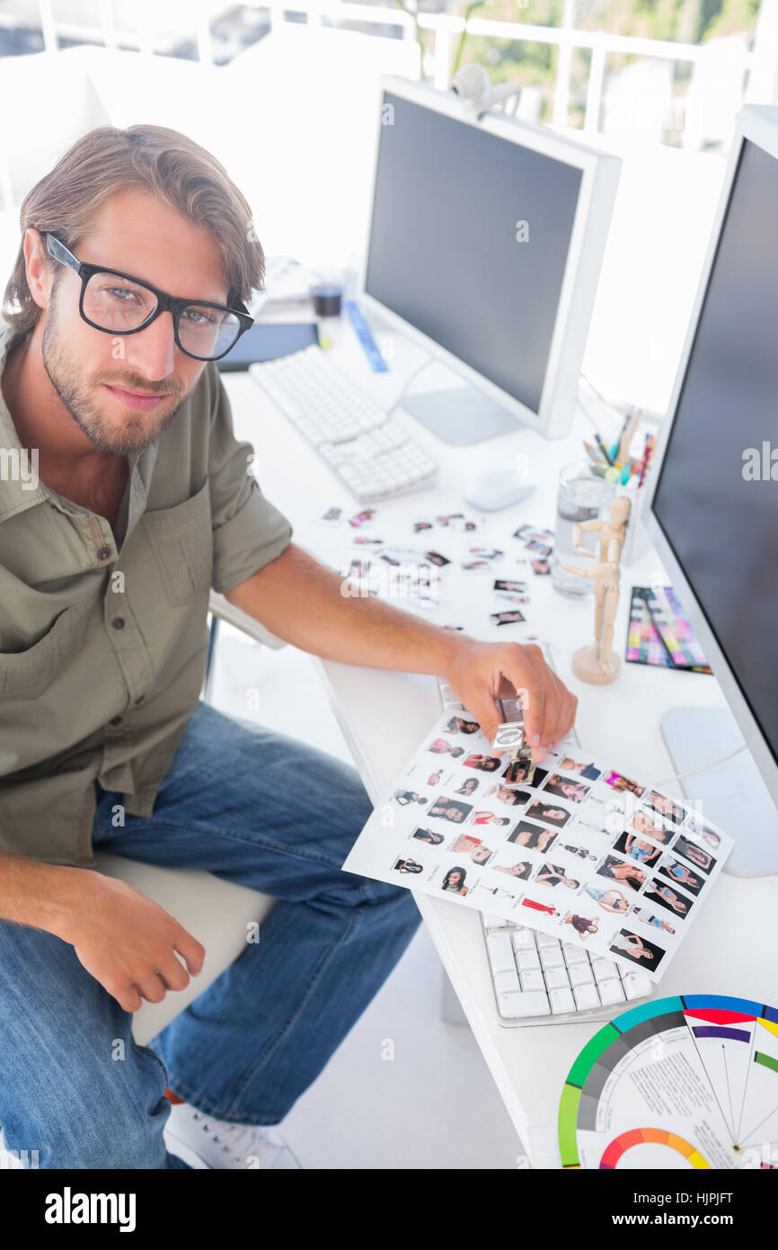 Photo editor looking up from his work in bright modern office Stock ...