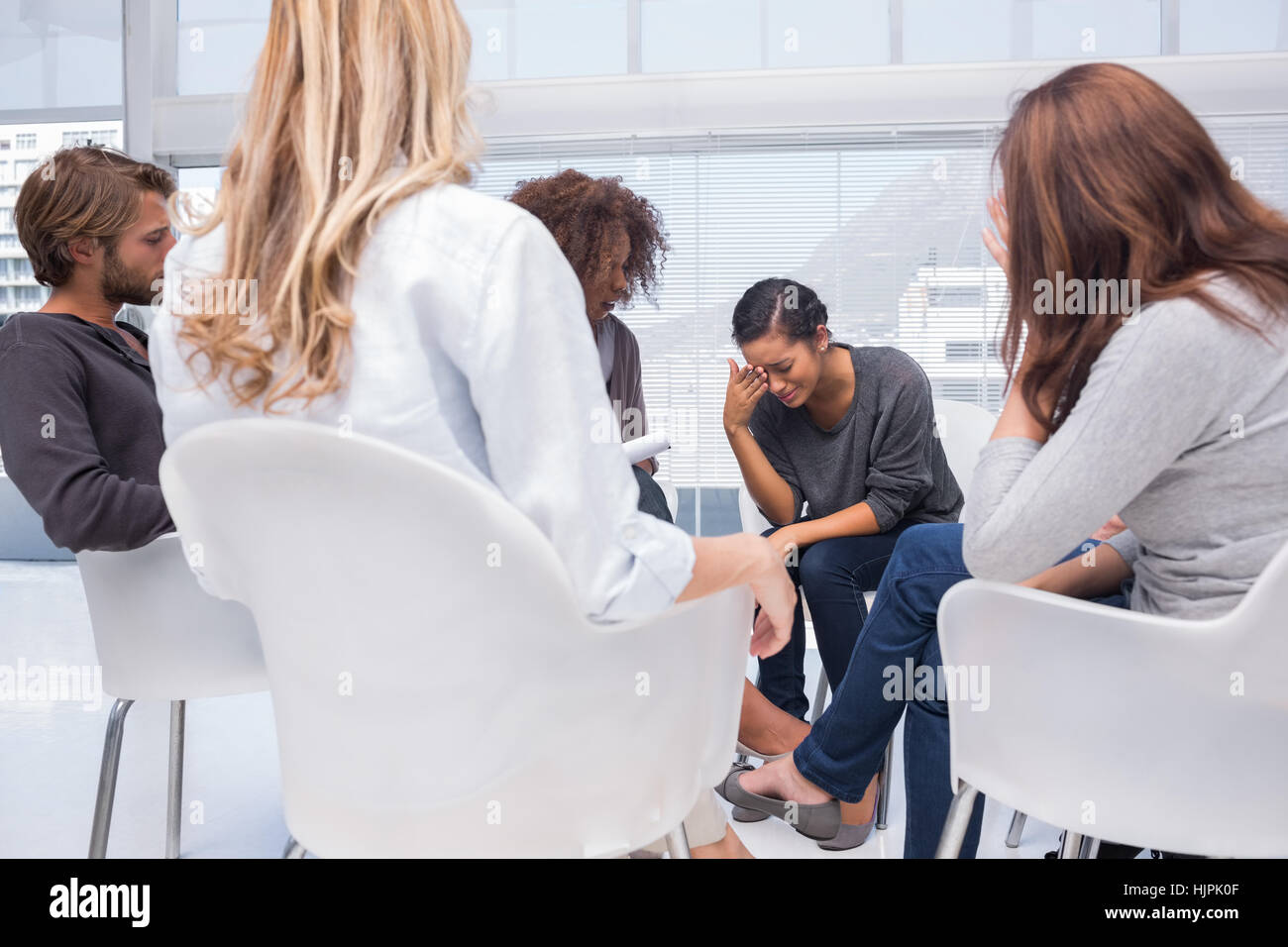 Therapist listening to woman crying at group therapy Stock Photo - Alamy