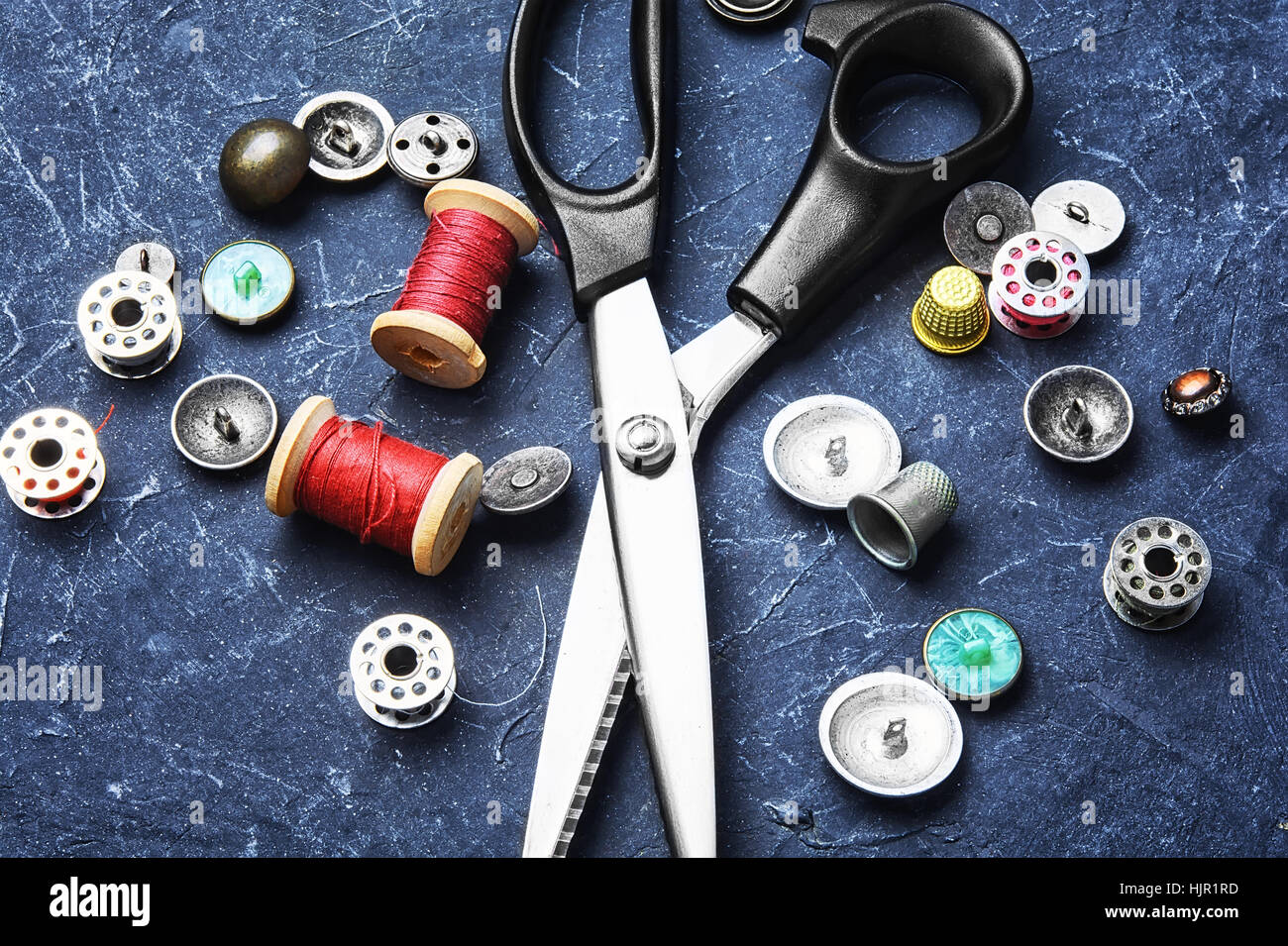 Stylish scissors for fabric,set of buttons and thread on slate dark ...