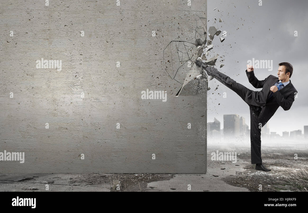 Businessman breaking stone wall with karate kick hi-res stock ...