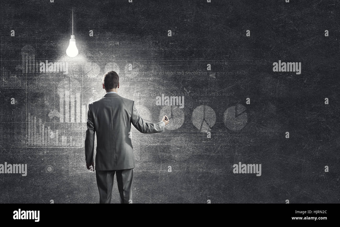 Rear view of businessman drawing marketing charts and graphs hi-res ...