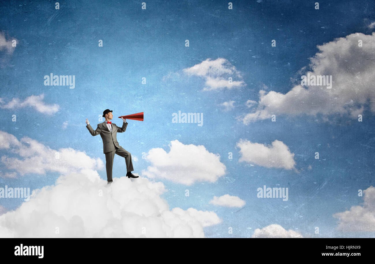 Young businessman on cloud screaming emotionally in paper trumpet hi ...