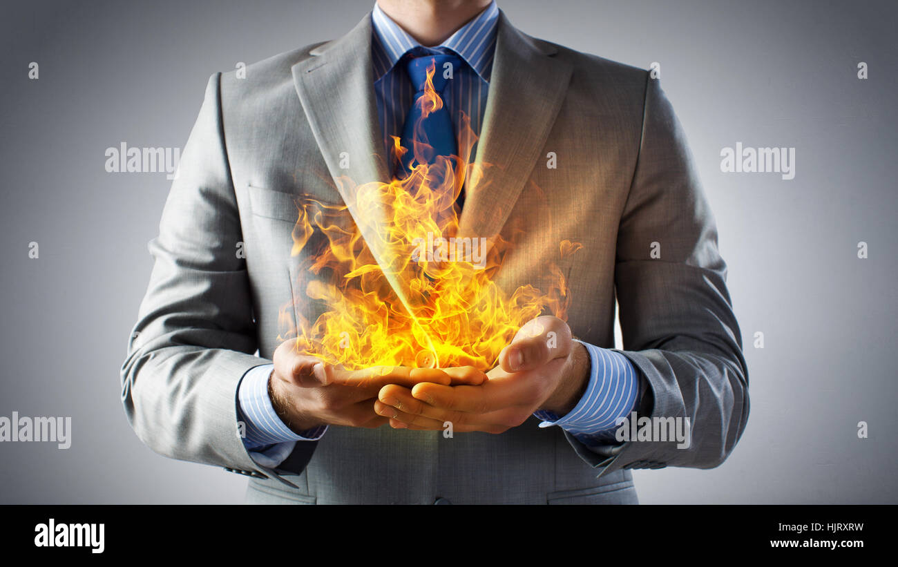 Young businessman holding fire flames in palm hi-res stock photography ...
