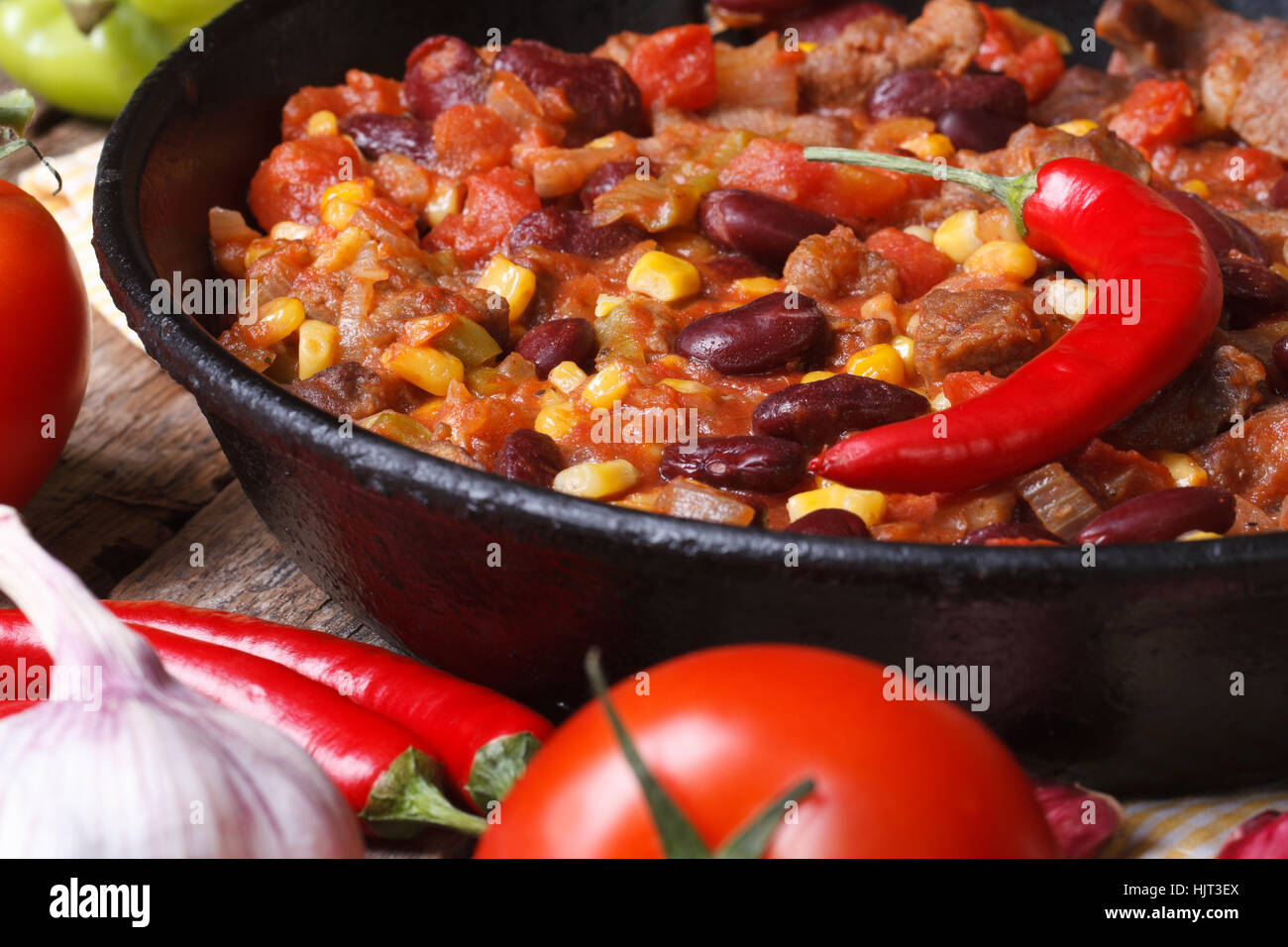 Mexican chili con carne close-up in a frying pan on a wooden background ...