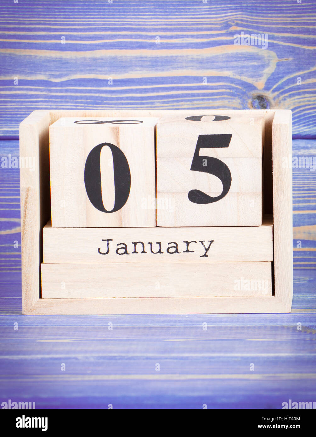 January 5th. Date of 5 January on wooden cube calendar, purple board as ...