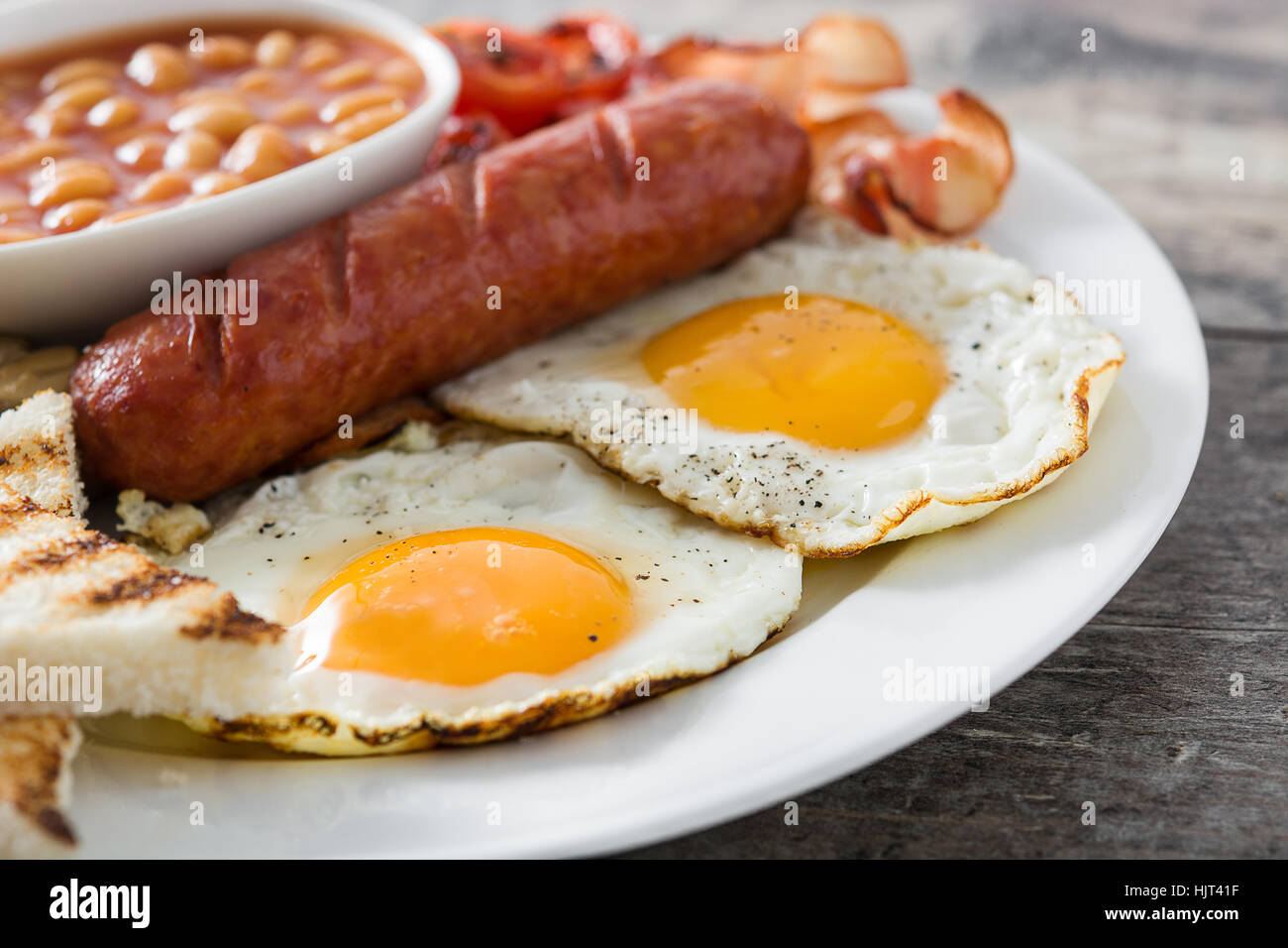 Traditional full English breakfast with fried eggs, sausages, beans ...