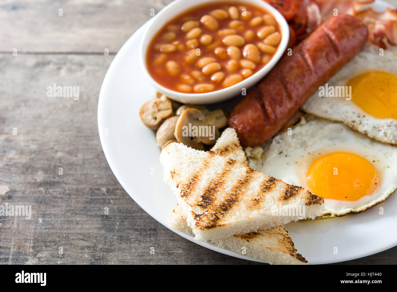 Traditional full English breakfast with fried eggs, sausages, beans ...