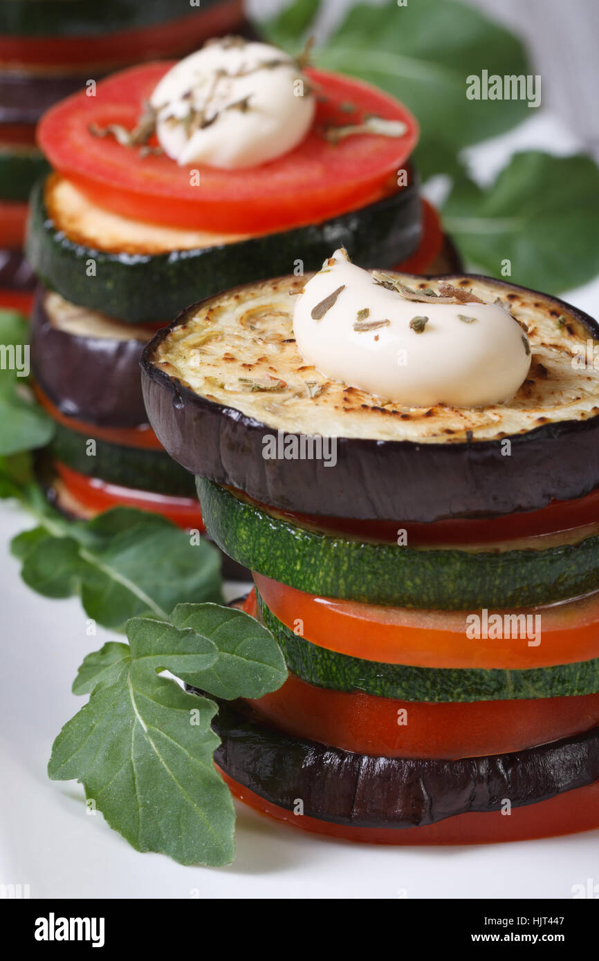 appetizer of baked vegetables with sauce and arugula close-up vertical ...