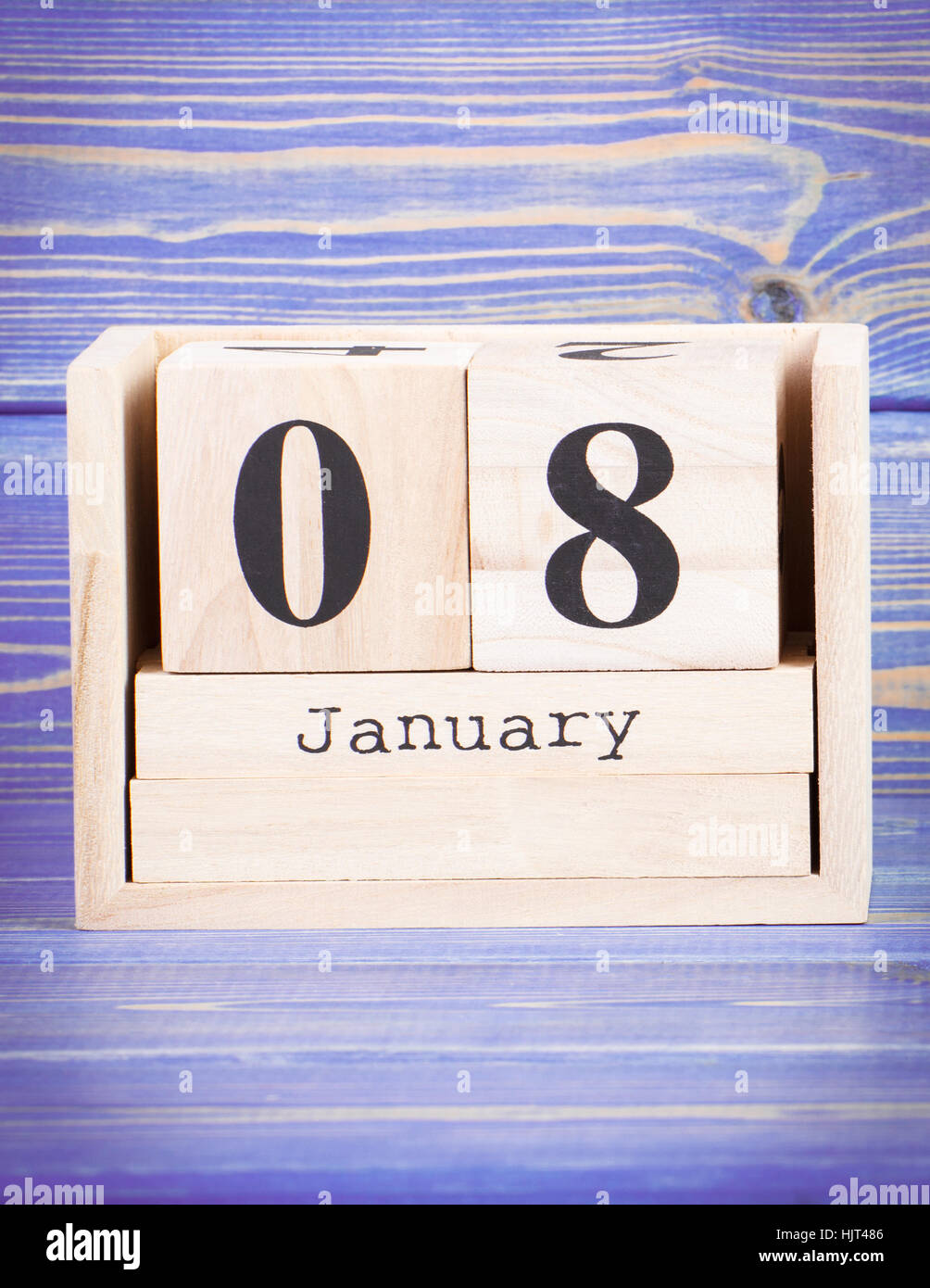 January 8th. Date of 8 January on wooden cube calendar, purple board as ...