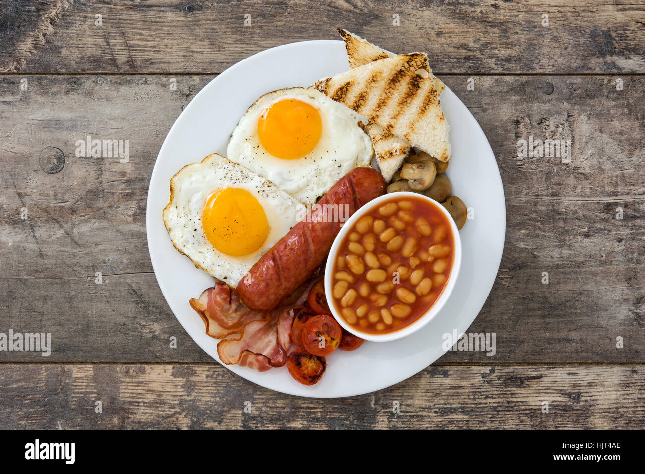 Traditional full English breakfast with fried eggs, sausages, beans ...