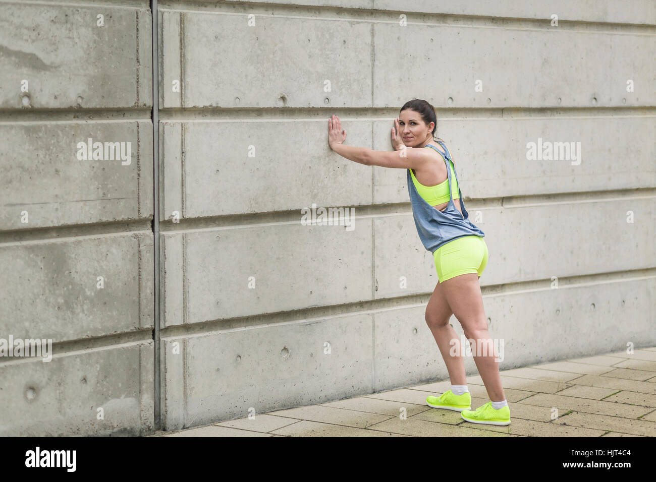 Woman stretching at building Stock Photo - Alamy