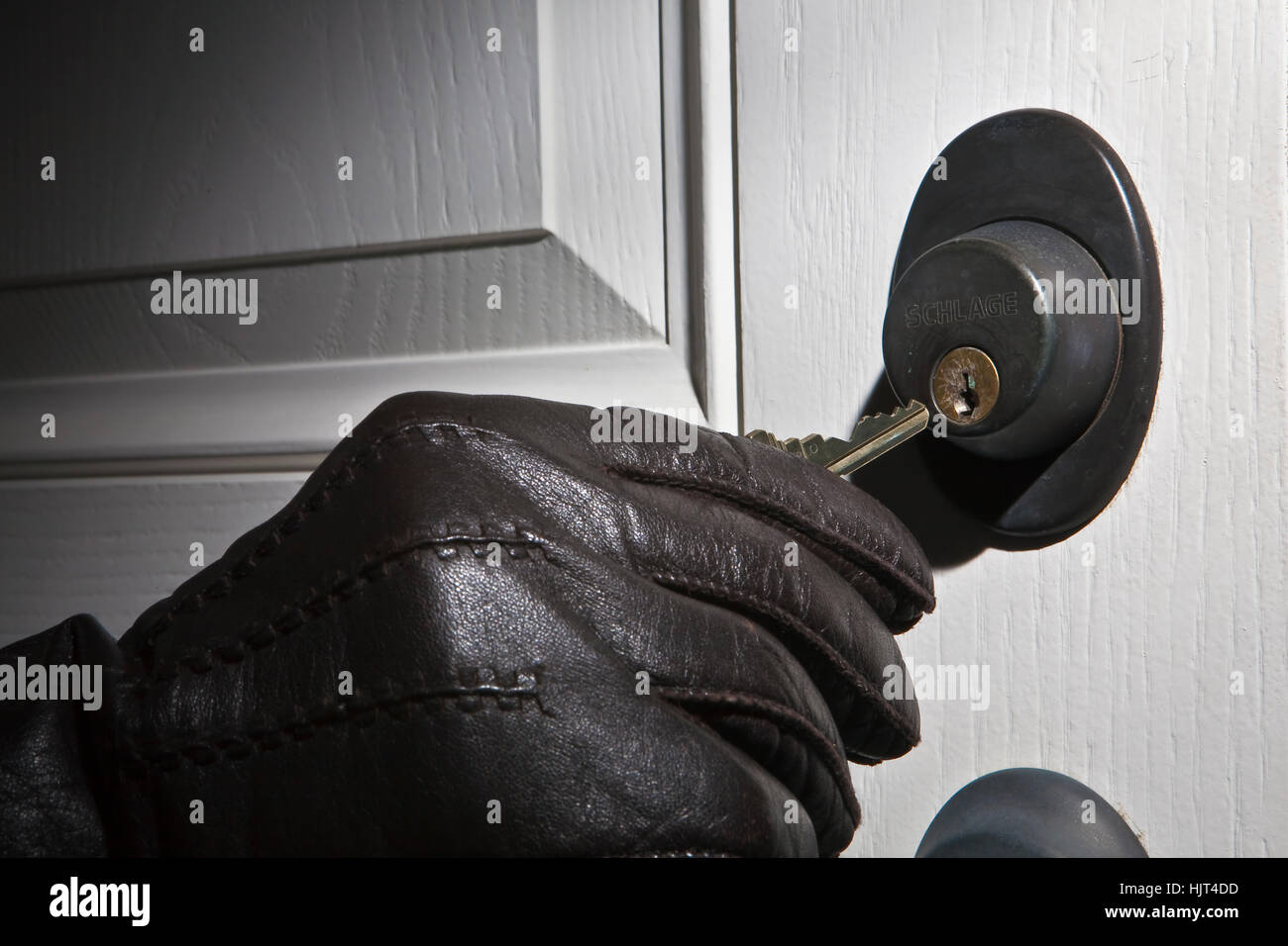 Hand putting key in door hi-res stock photography and images - Alamy