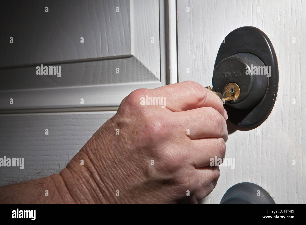 Hand putting key in door hi-res stock photography and images - Alamy