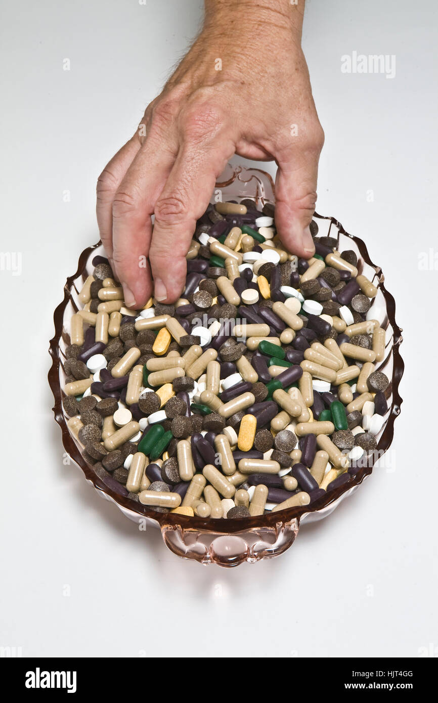 Cutout/silo of hand holding a variety of colored pills from a candy ...