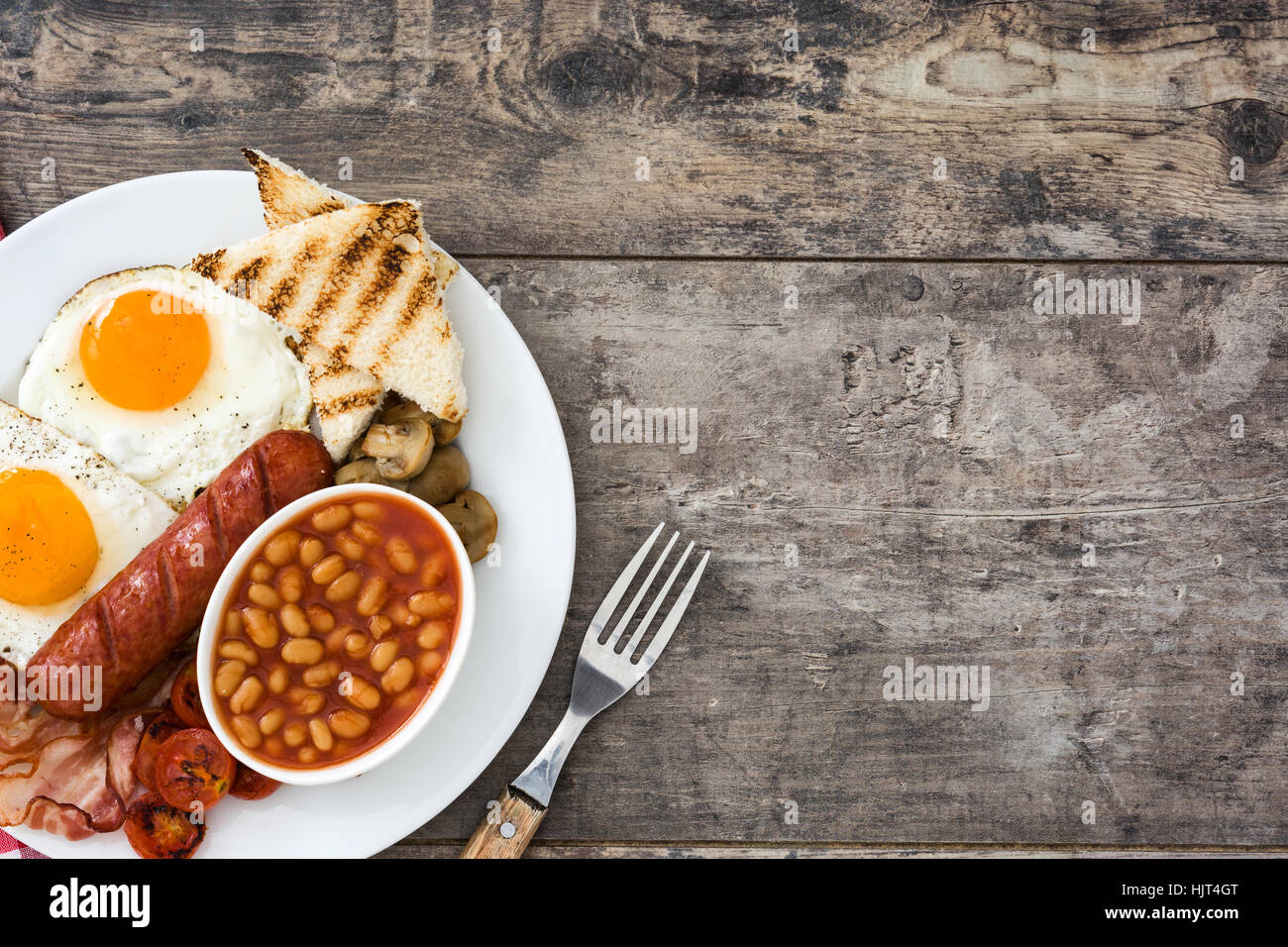 Traditional full English breakfast with fried eggs, sausages, beans ...