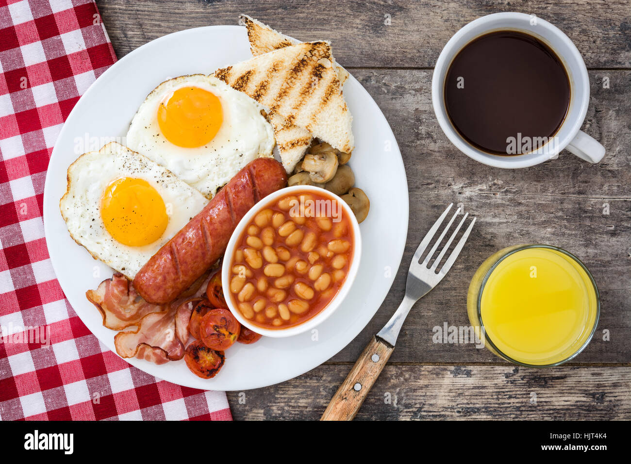 Traditional full English breakfast with fried eggs, sausages, beans ...