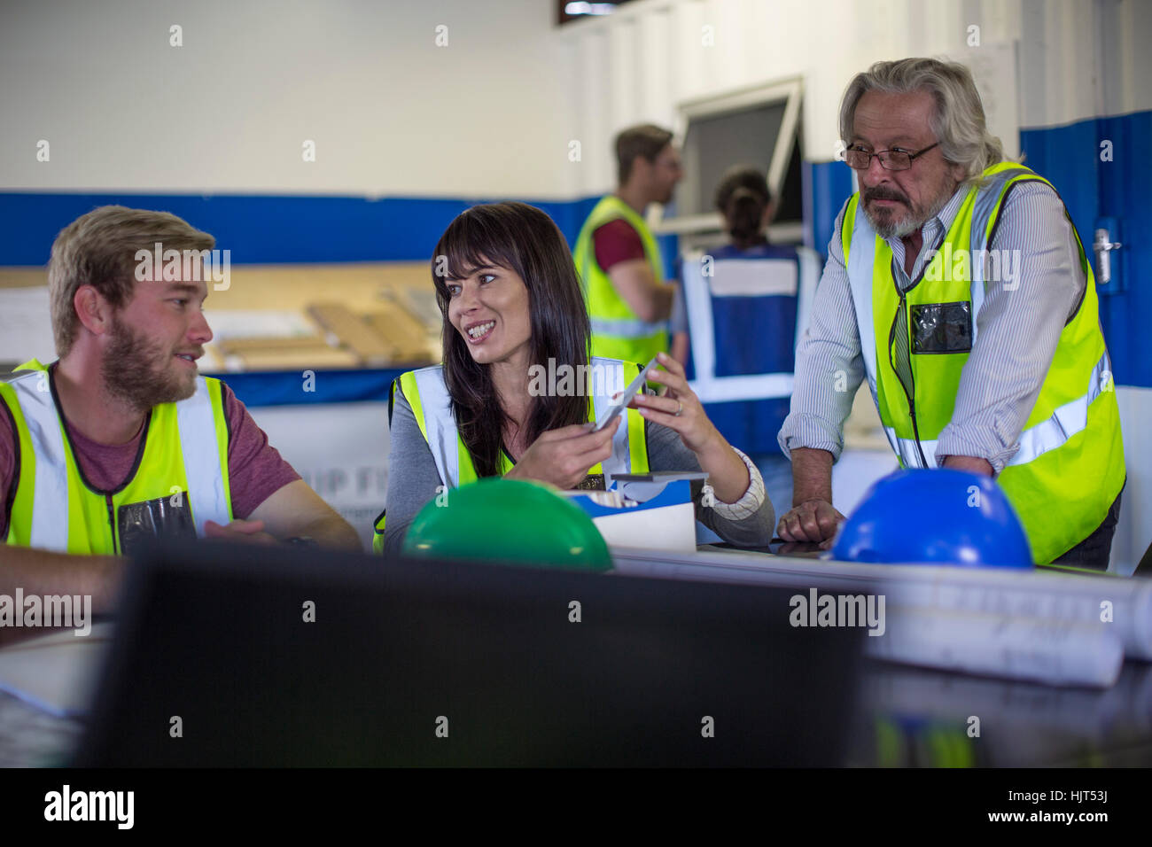 Construction worker and engineer discussing project in site office ...