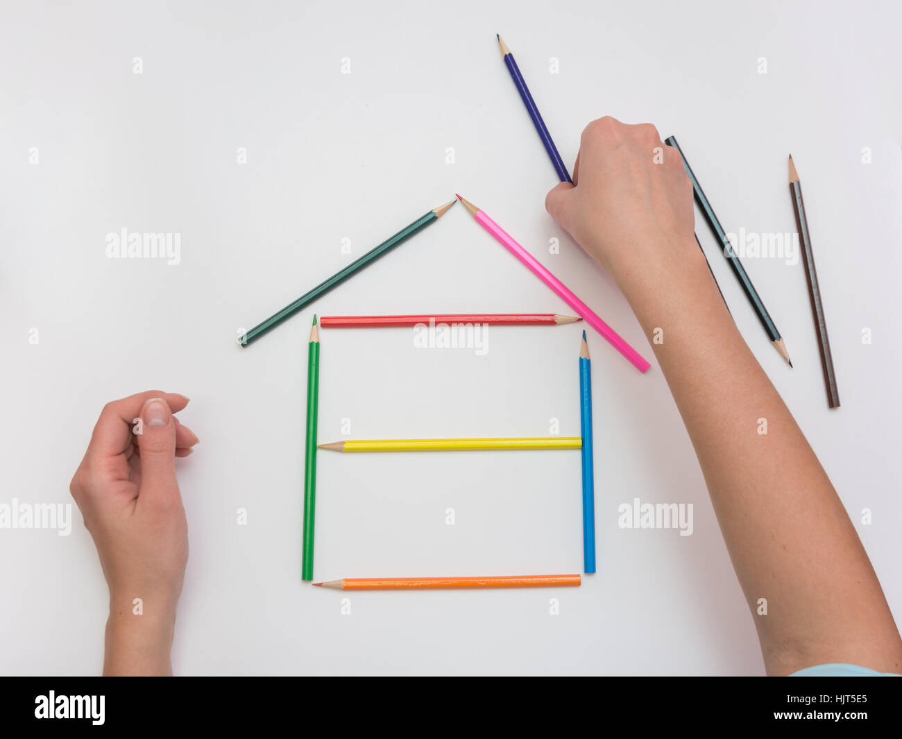 Women's hands are building a wooden house from pencils Stock Photo - Alamy