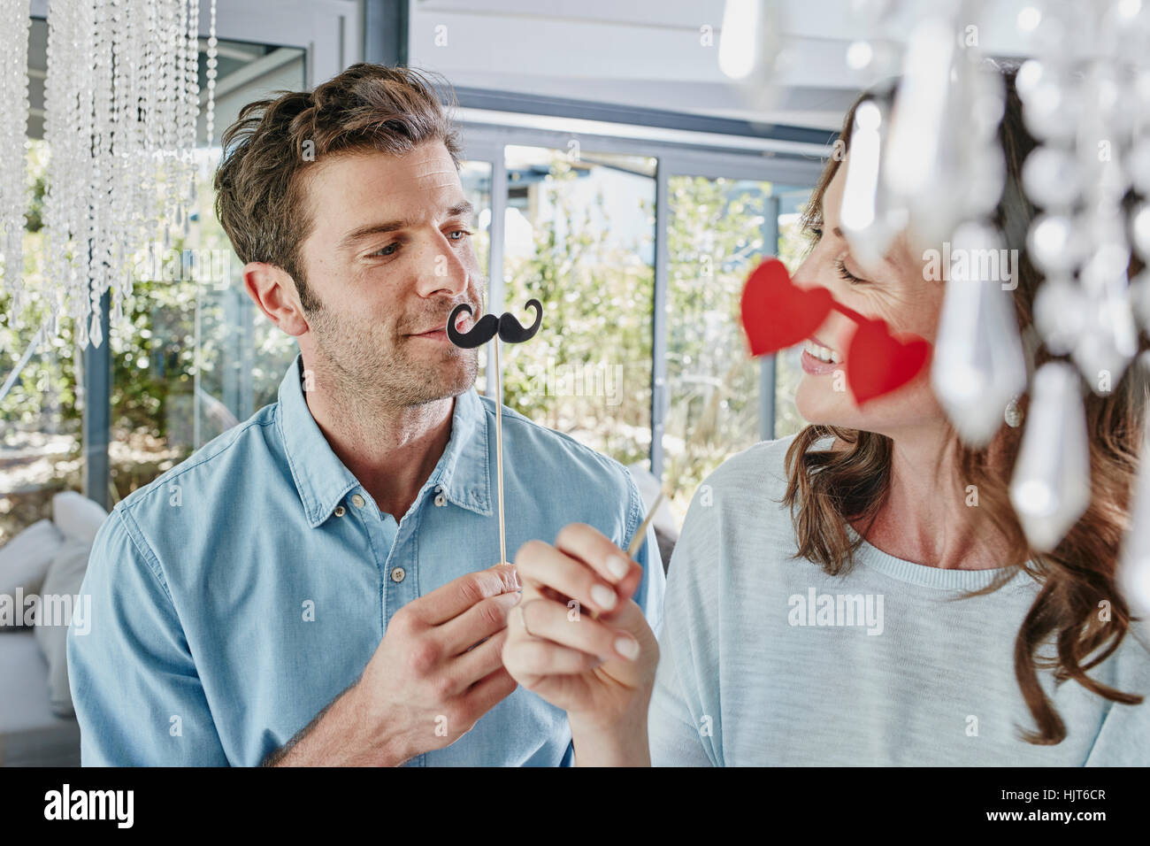 Couple with paper moustache and heart-shape mask Stock Photo - Alamy