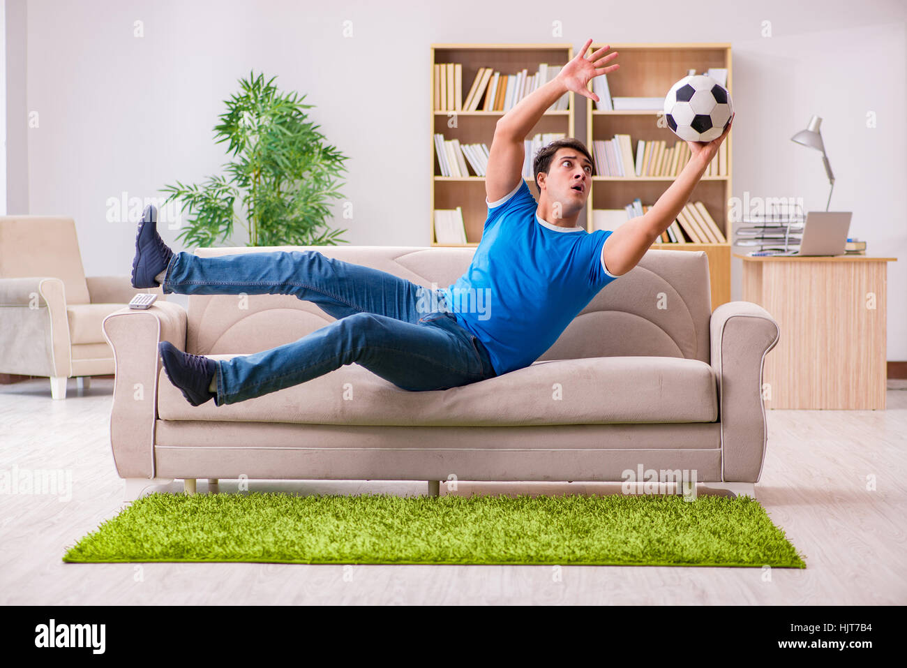 Man watching football at home sitting in couch Stock Photo - Alamy