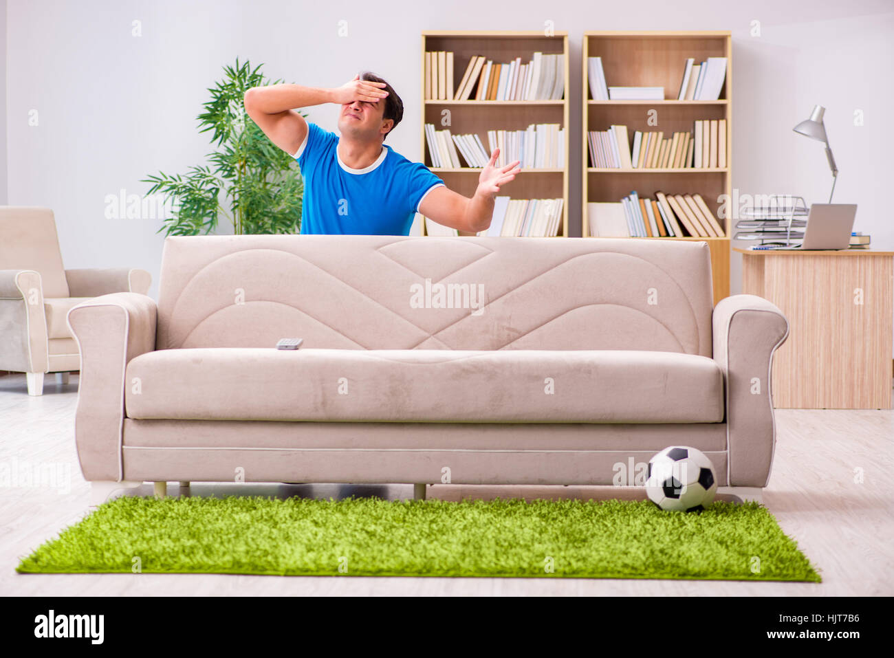 Man watching football at home sitting in couch Stock Photo - Alamy