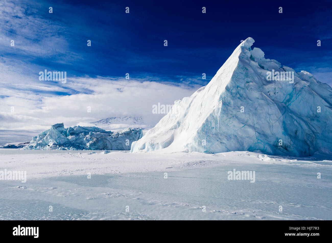 An enormous jagged iceberg trapped in frozen sea ice Stock Photo - Alamy