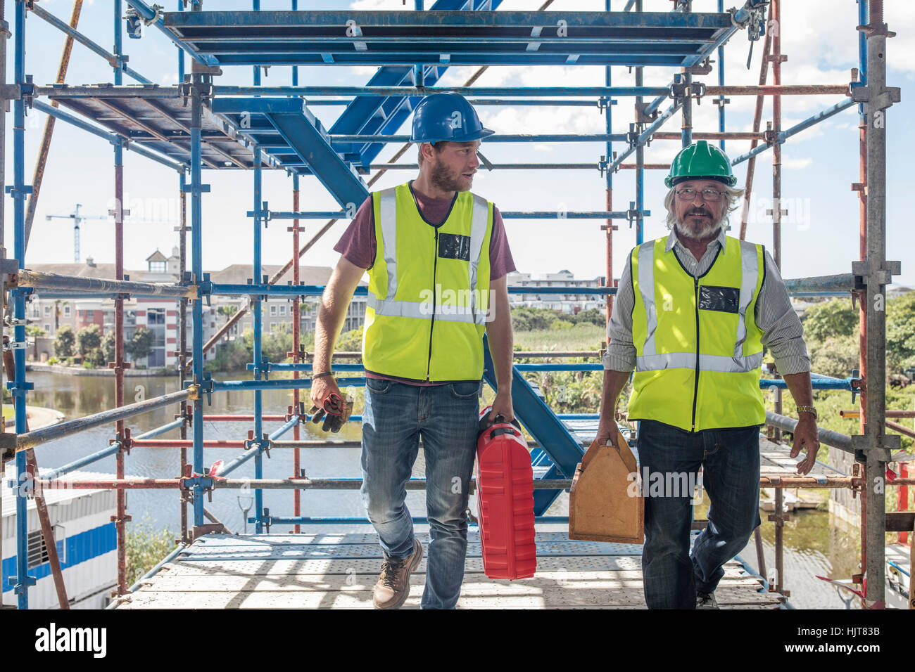 Construction workers on construction site carrying tool boxes Stock ...