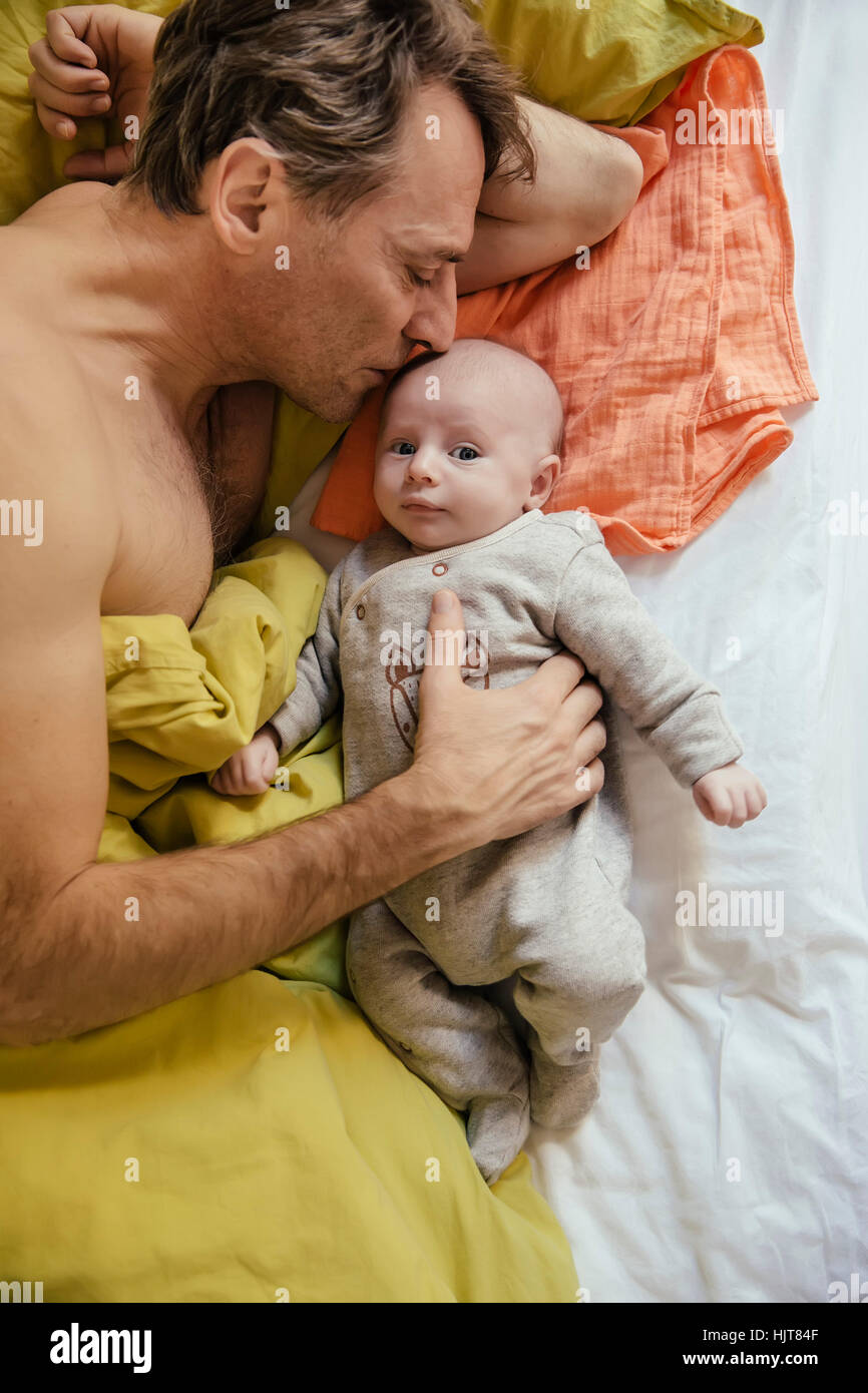 Father cuddling in bed with his newborn baby Stock Photo - Alamy