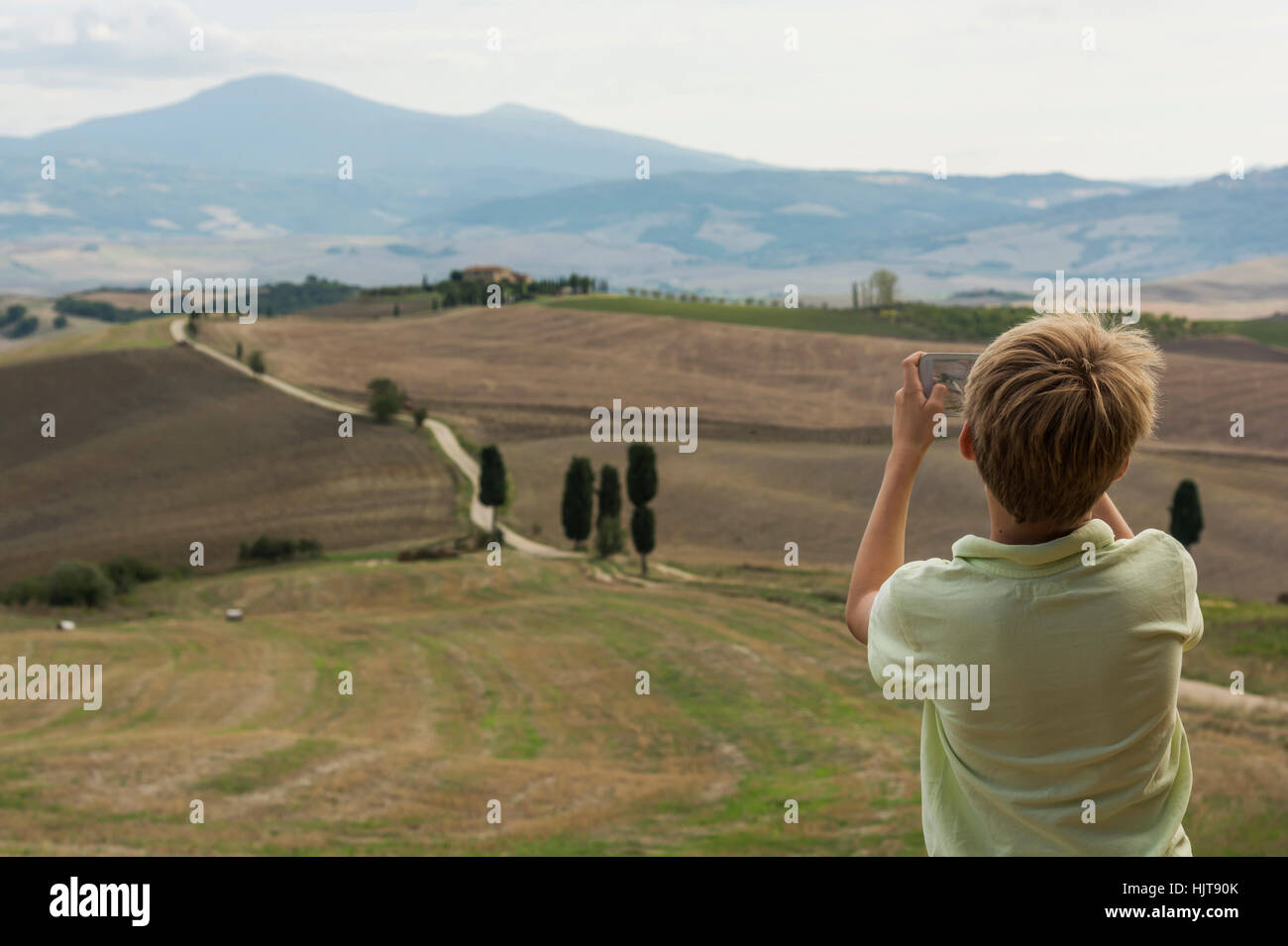 Italy, Tuscany, Boy taking pictures of landscape Stock Photo - Alamy